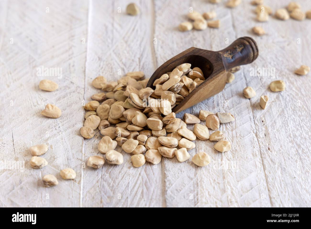 Scoop of raw dry Grass pea close up on wood. Healthy, protein source ...