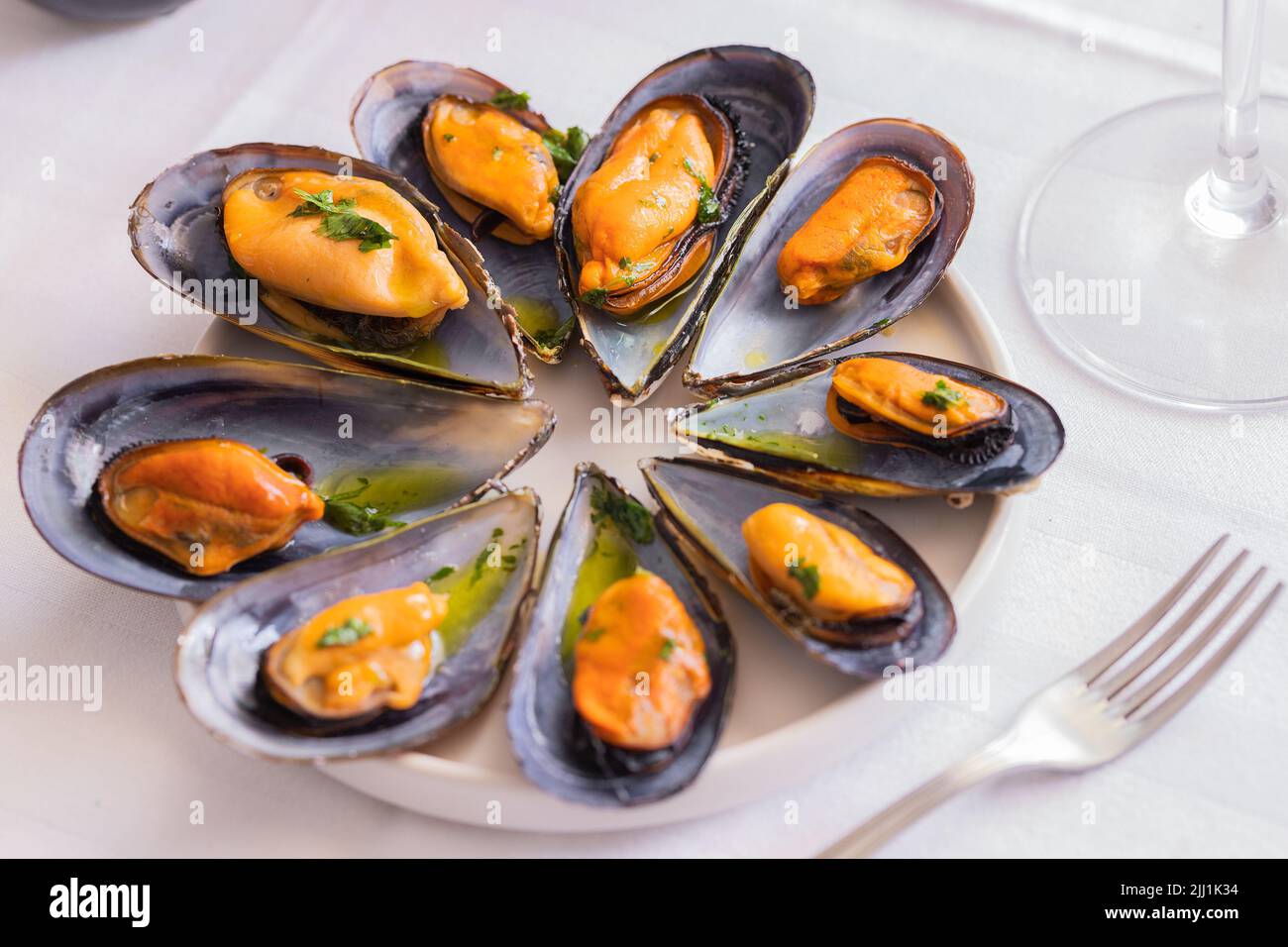 Steamed black mussels cooking in sauce and served with wine. Popular ...