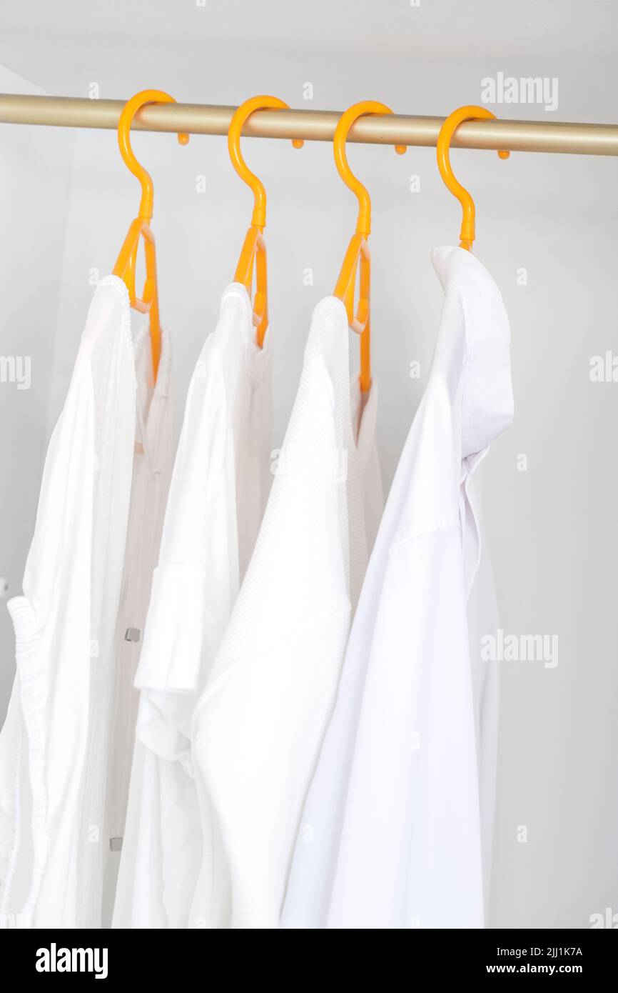 White shirts hanging on rack in wardrobe closet. Female different ...