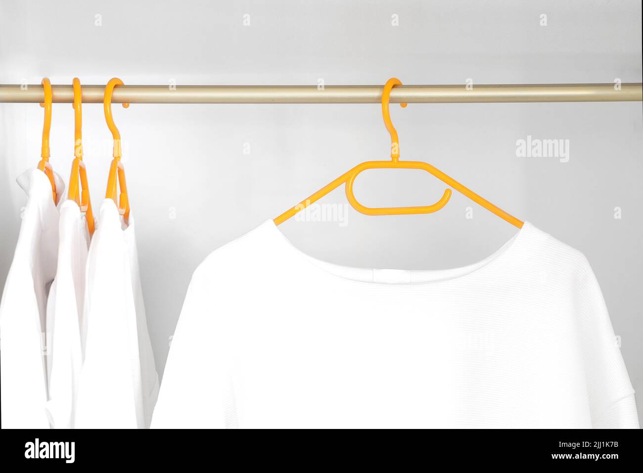 White shirts hanging on rack in wardrobe closet. Female different ...