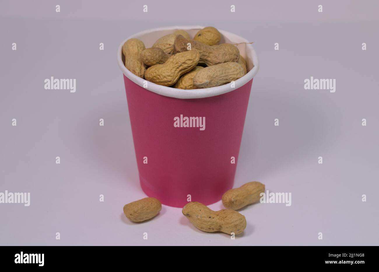 Shelled peanuts in paper cup on a white surface Stock Photo - Alamy