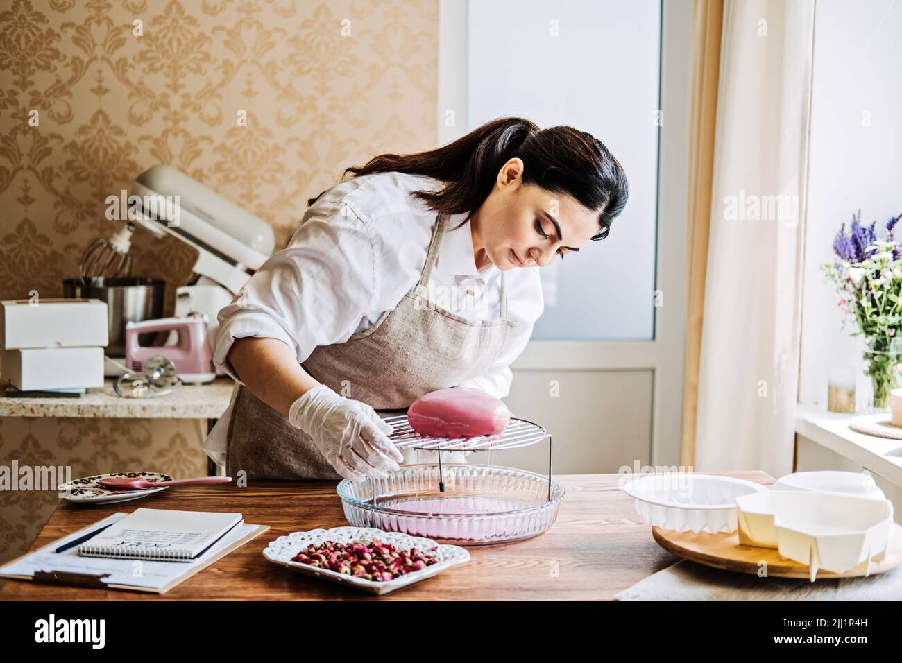 Central Asian Arabic woman pastry chef making Mirror Glaze Mousse cake ...