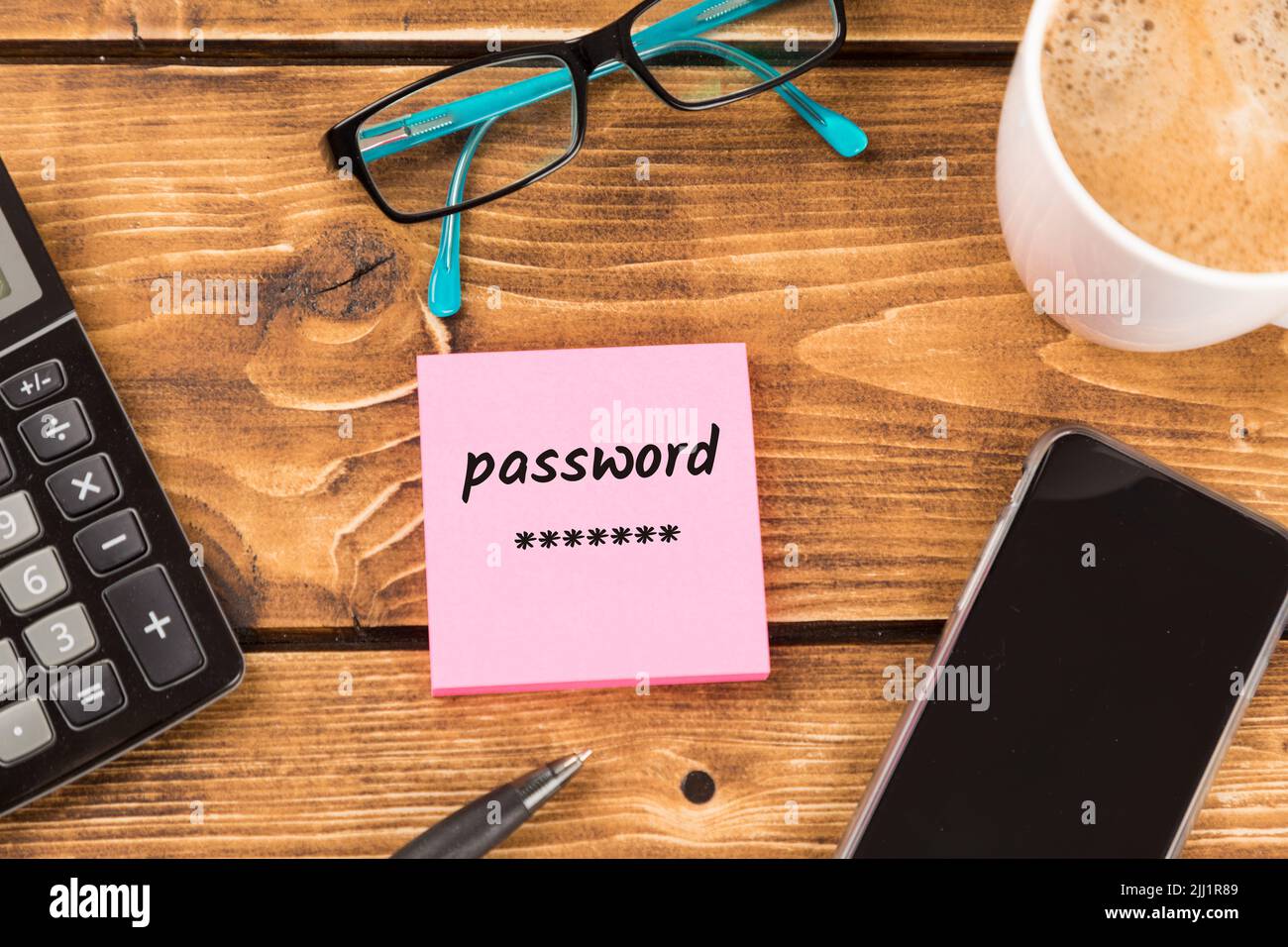 A desk with 'password' text on pink paper surrounded by calculator ...