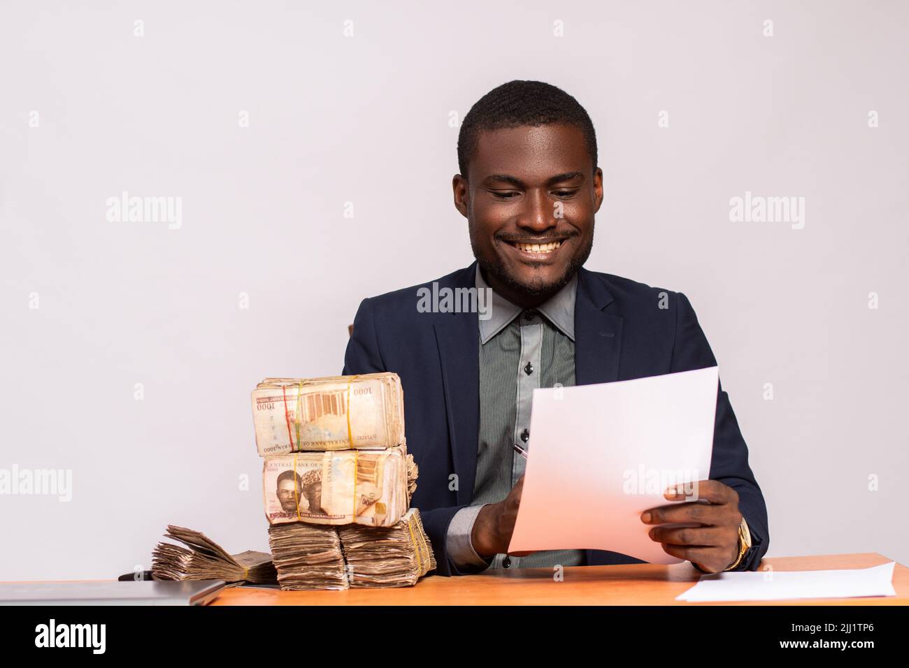 african businessman at work with lots of money Stock Photo - Alamy