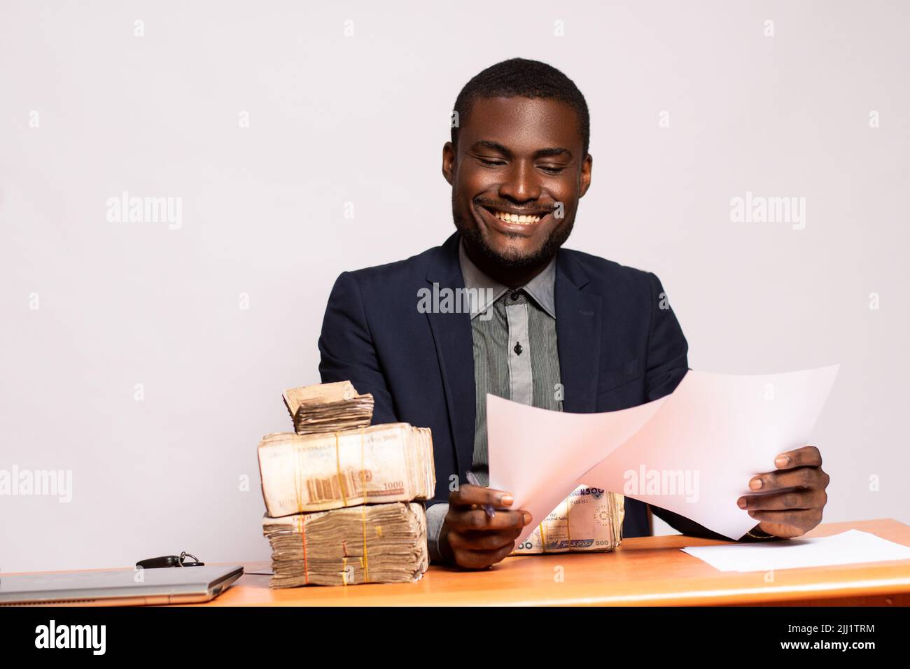 african businessman at work with lots of money Stock Photo - Alamy