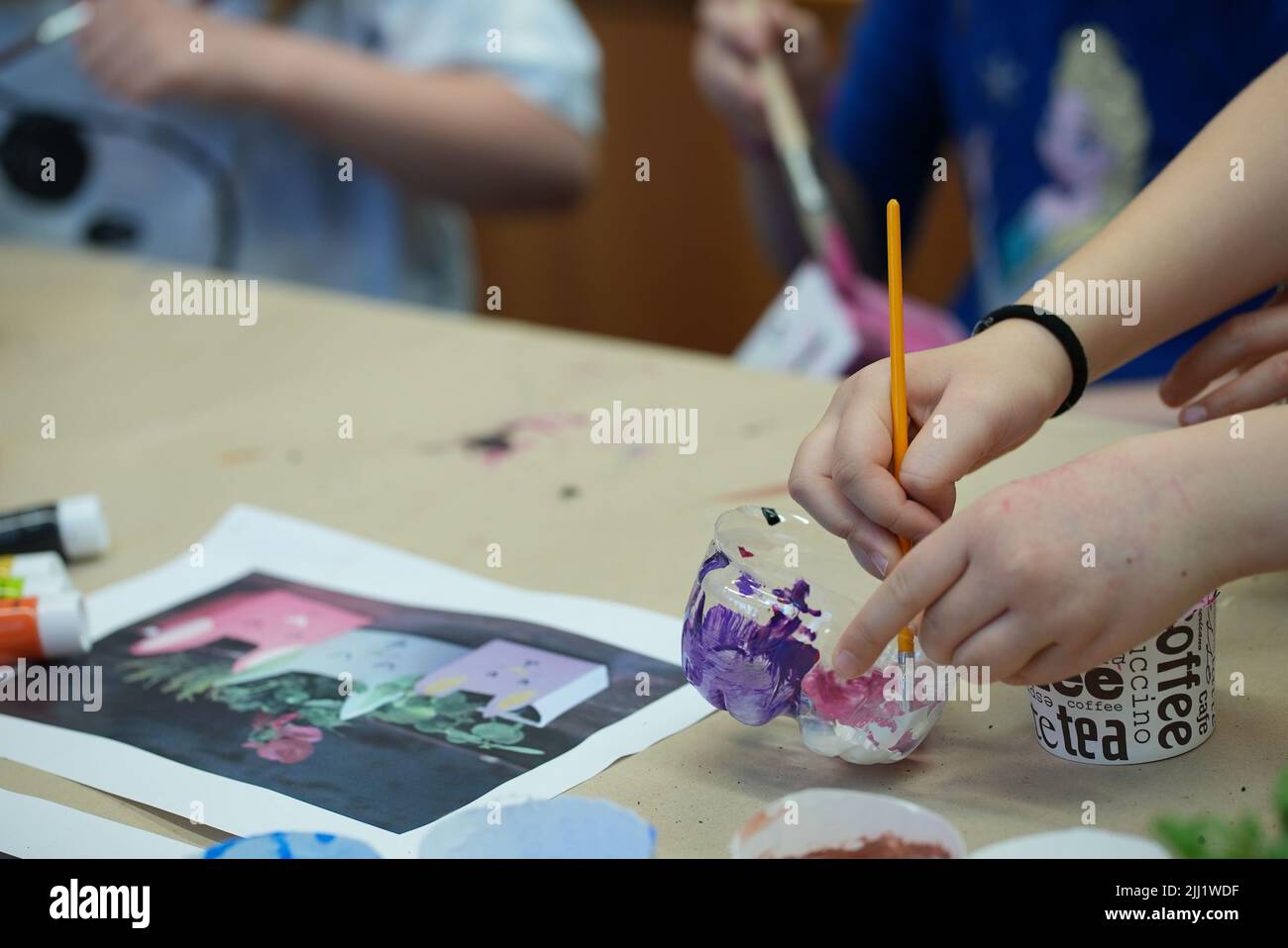 Kid painting something on a paper at school Stock Photo - Alamy
