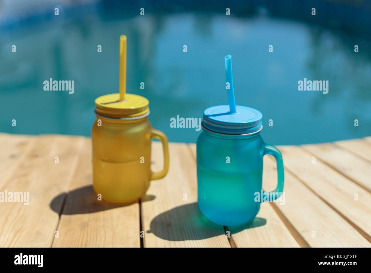 two cocktails of yellow and blue standing by the pool. Pool party ...