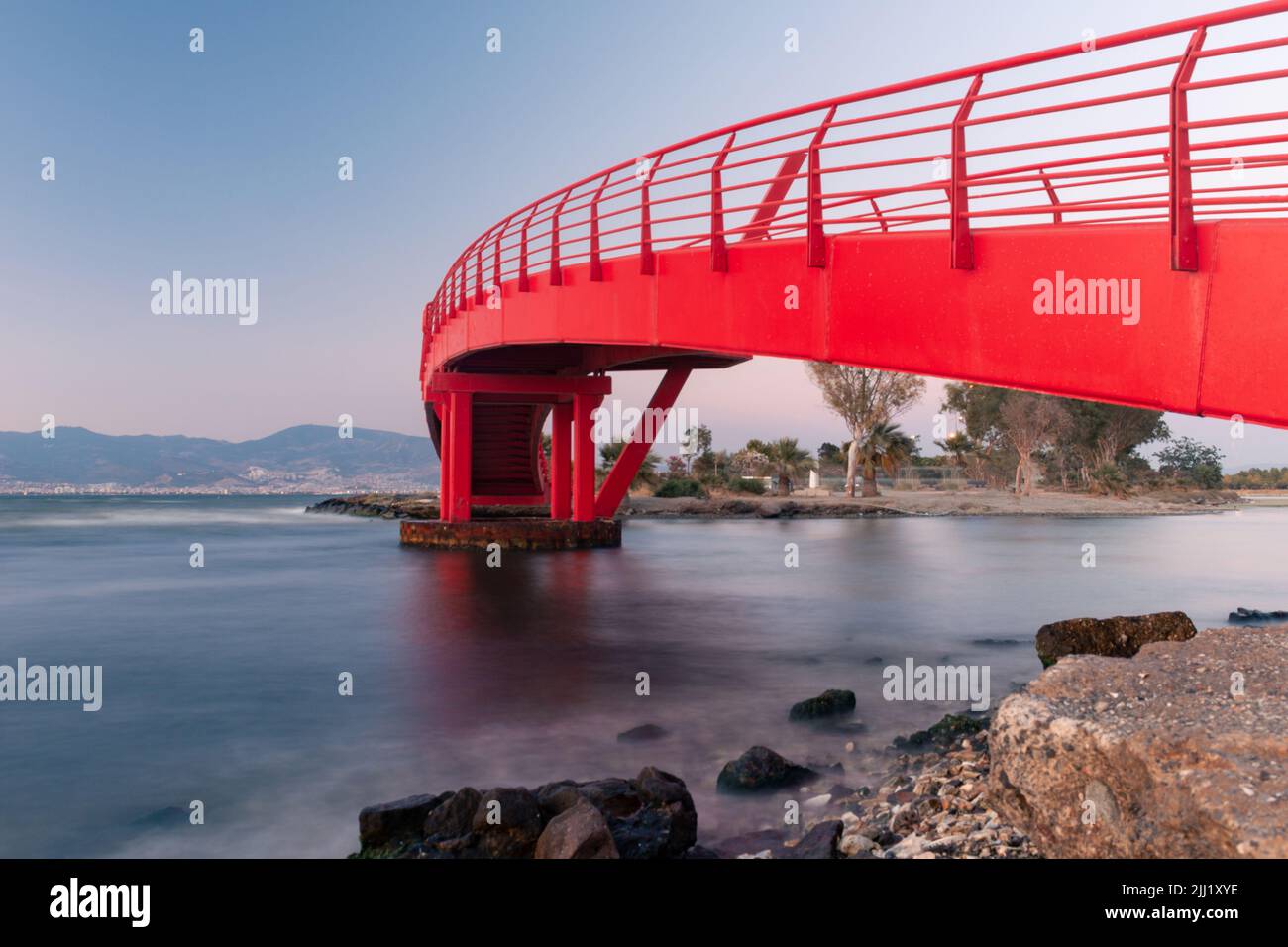 A Horizontal shot of a red metal bridge crossing over the sea. Long ...
