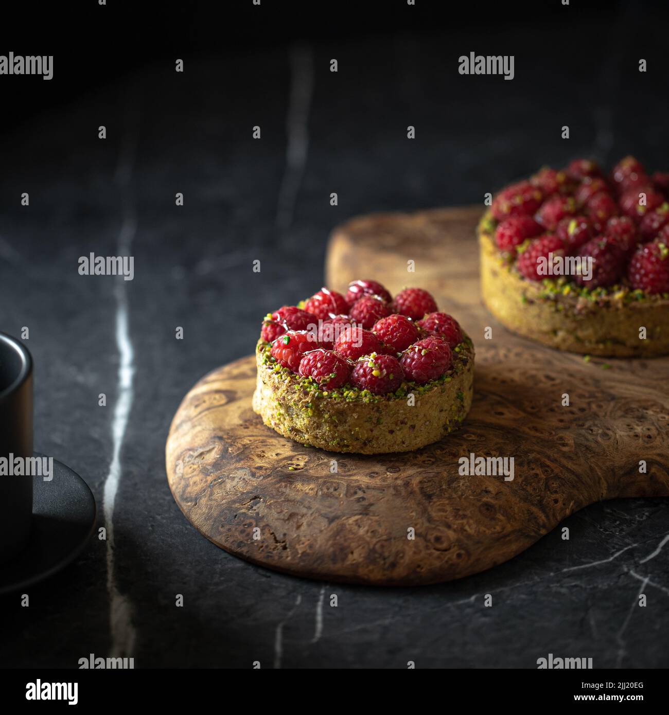 Two delicious raspberry tartlets with pistachios Stock Photo - Alamy