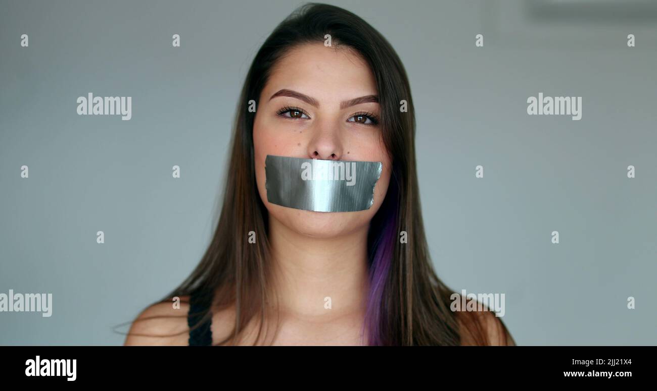 Woman mouth taped looking at camera Stock Photo - Alamy