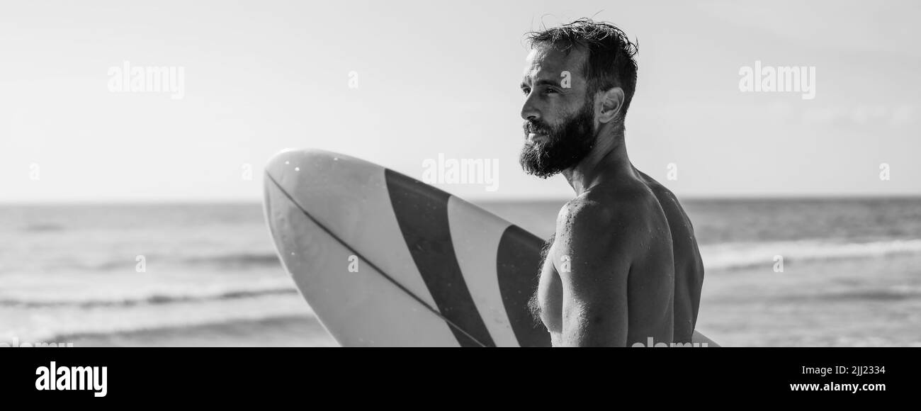 Horizontal banner or header with surfer holding his surfboard on the ...