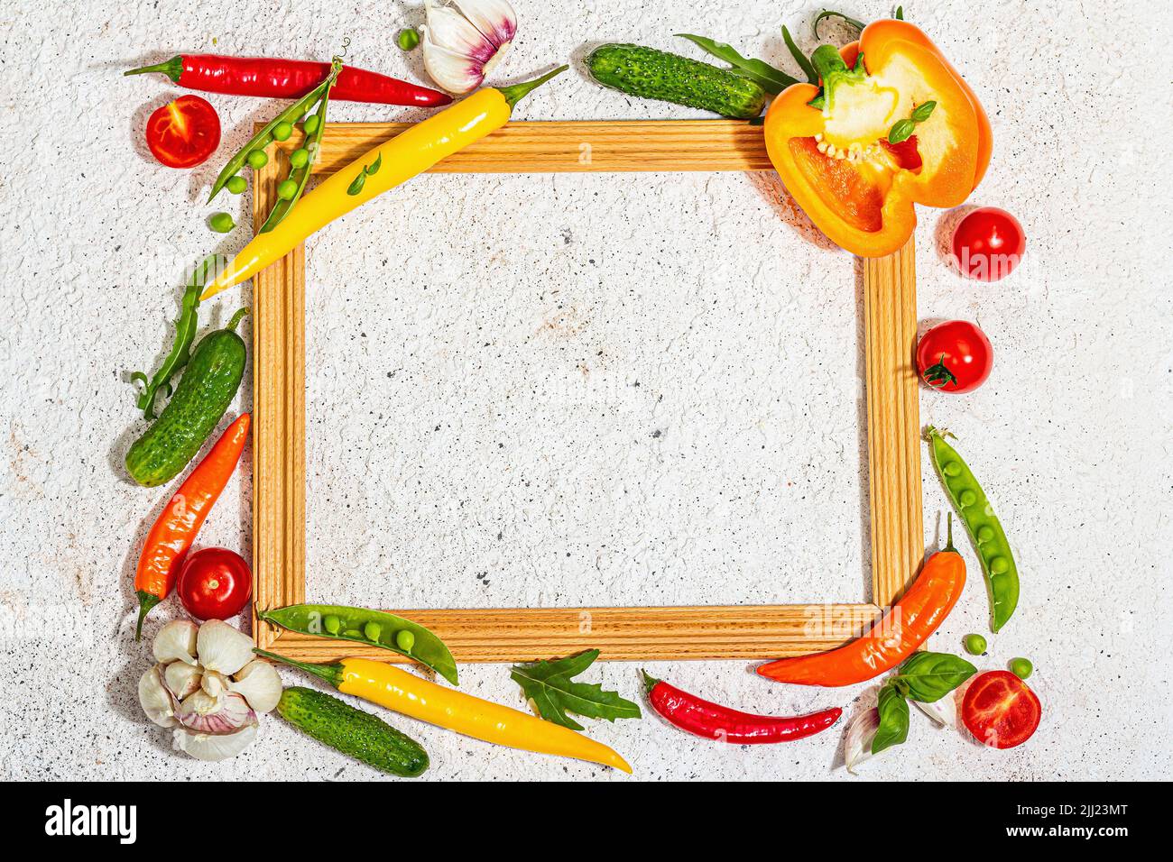 Assorted fresh vegetables and spices around wooden frame. Ripe yellow ...