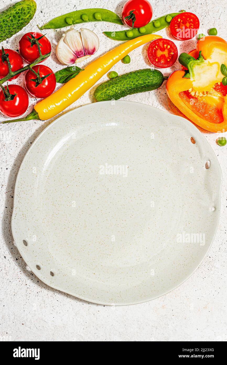 Vegan table setting. Assorted of ripe fresh vegetables, empty plate ...