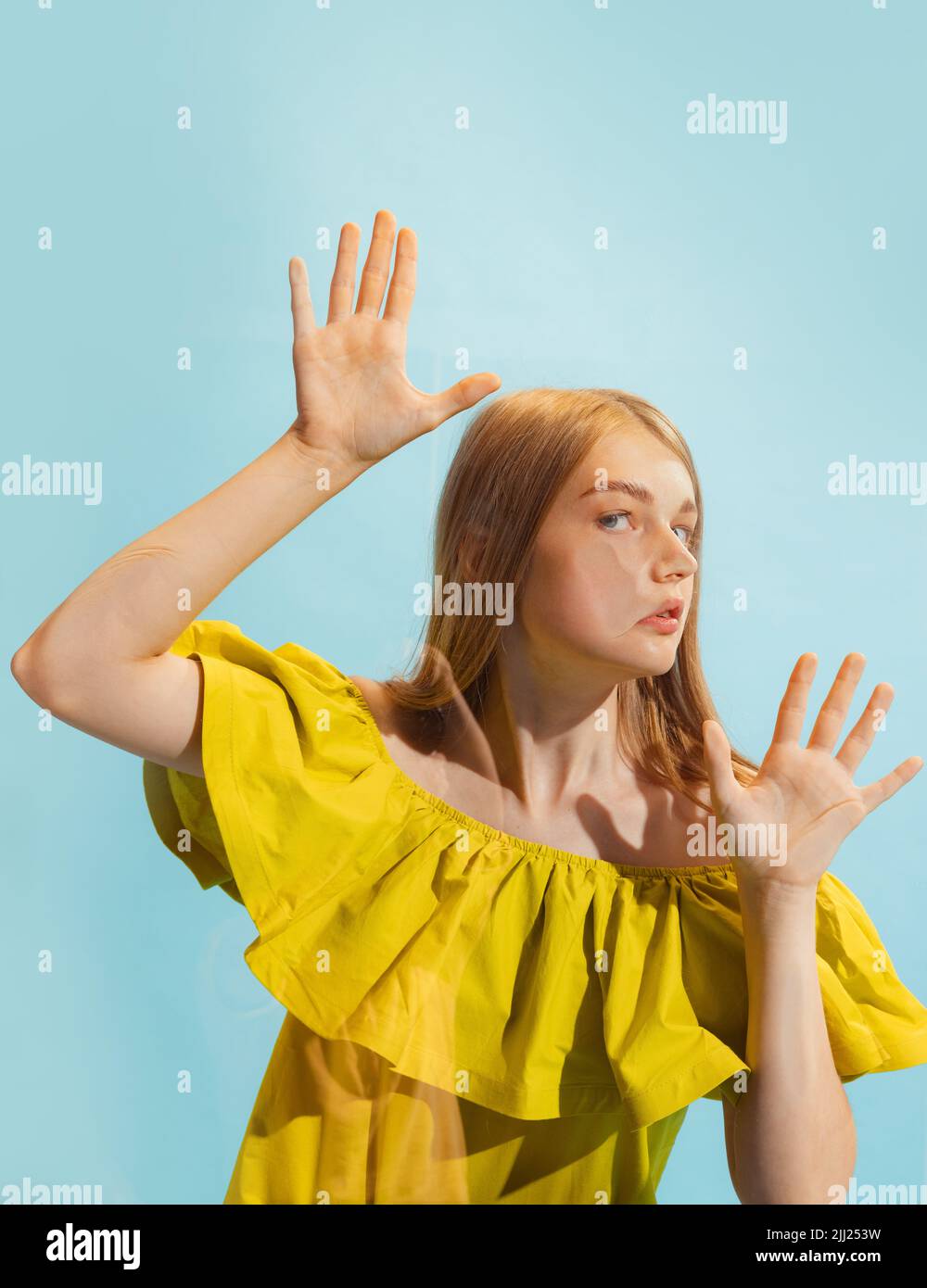 Young pretty girl, student leaned against transparent glass isolated on ...