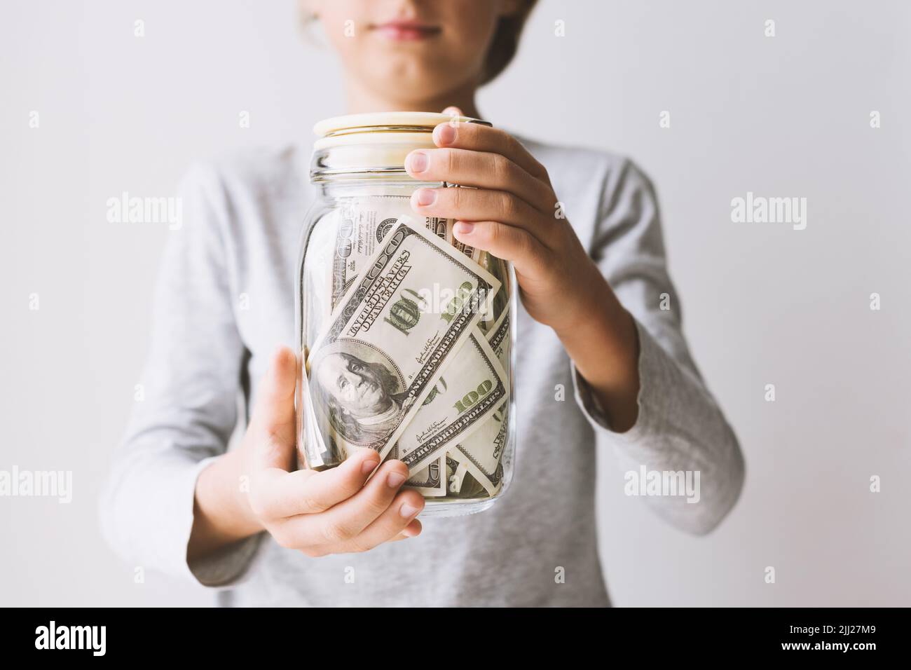 Kid save money. Put money in a piggy bank Stock Photo - Alamy