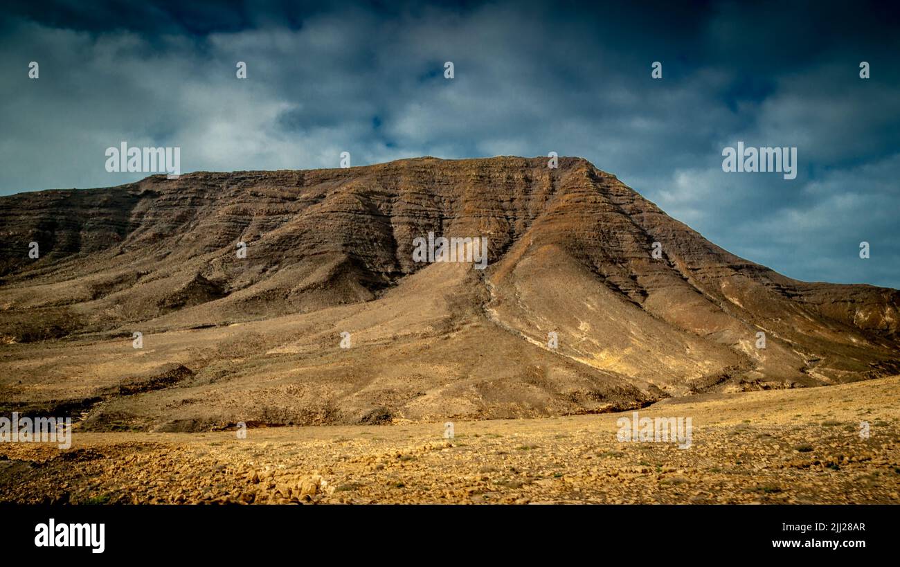 A scenic view of a volcanic mountain under blue sky covered with white ...