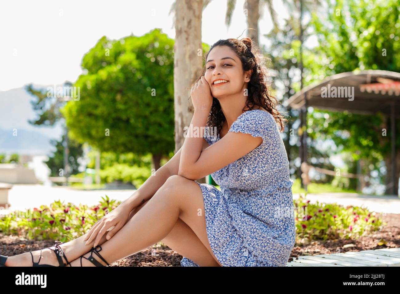 Happy woman wearing summer dress standing on city park, outdoors ...