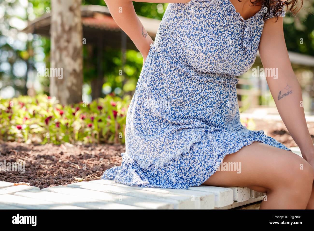 Brunette millennial woman wearing summer dress standing on city park ...