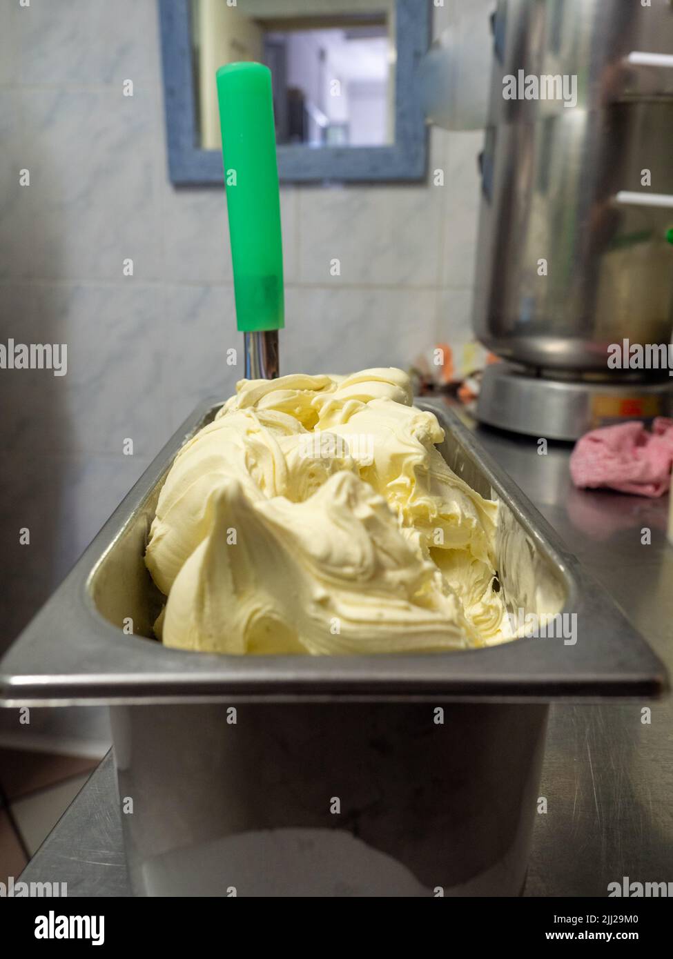 Producing cream ice cream flavors into steel container. Industrial ...