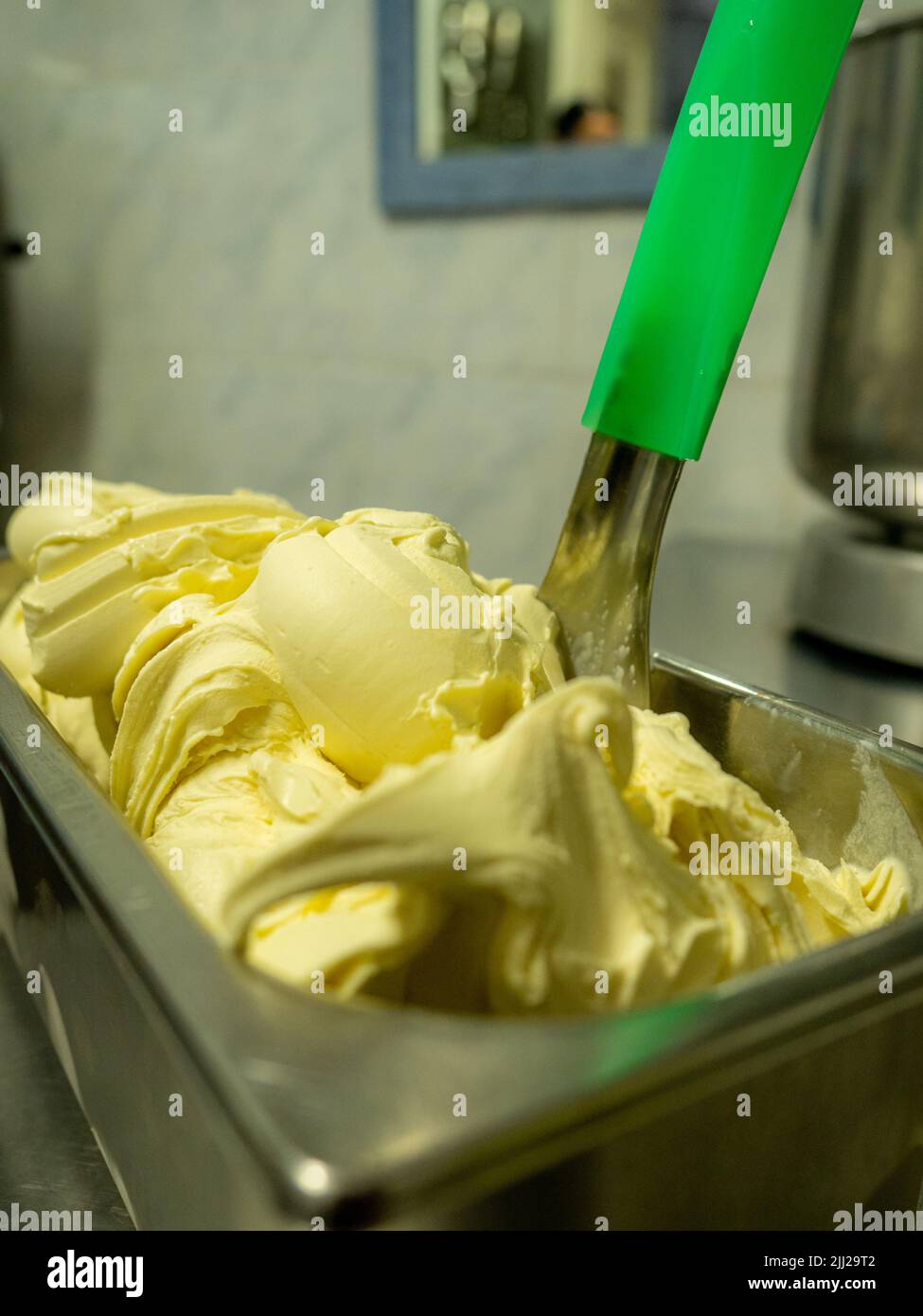 Producing cream ice cream flavors into steel container. Industrial ...