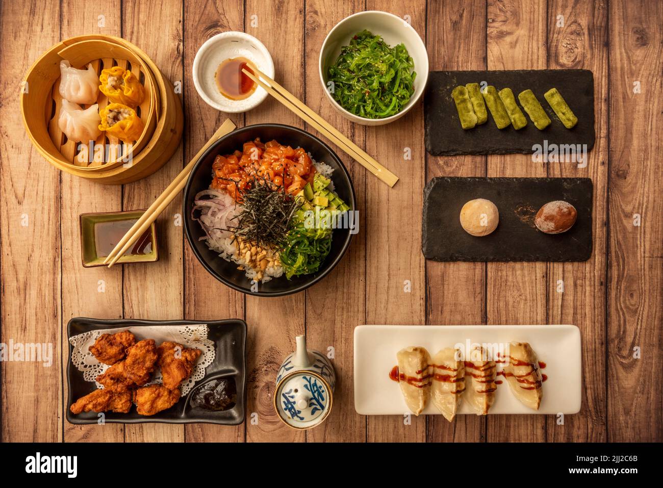 Asian food dishes set with green tea sweets, gyozas, mochis and poke ...