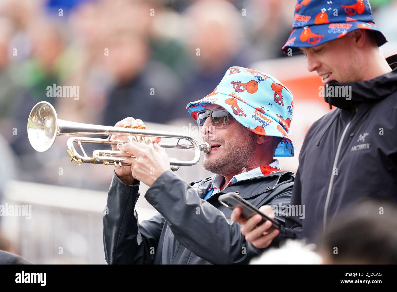Crowds play a trumpet in the stands during the second one day ...