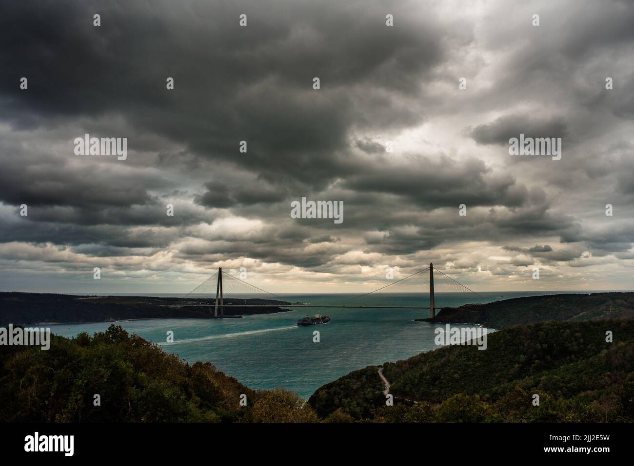 ship sailing in cloudy weather bridge in background Stock Photo - Alamy
