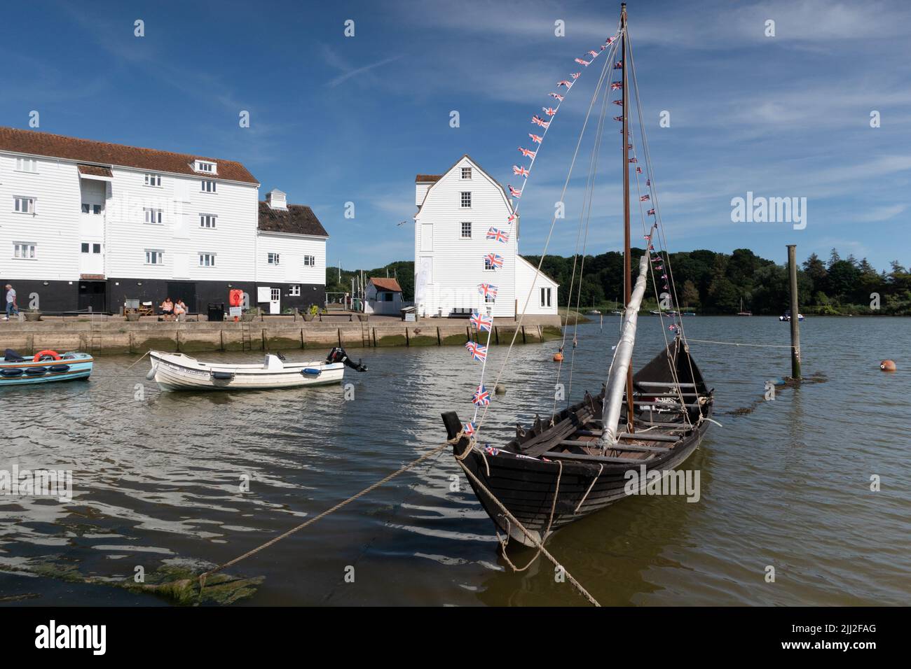 View with moored old open barge boat and Woodbridge Tide mill Suffolk ...