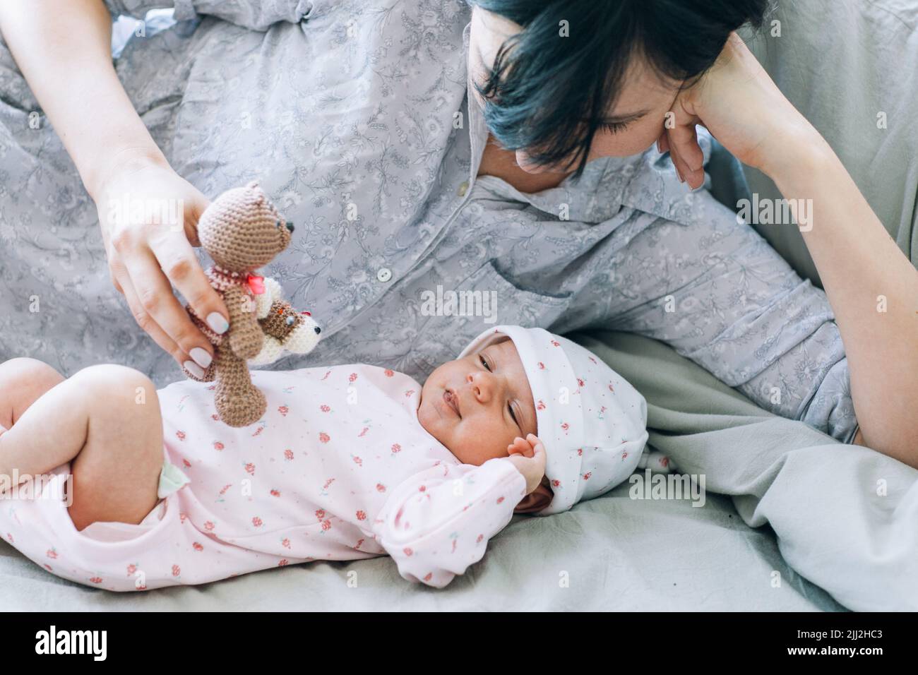 mother play with her newborn baby a teddy bear toy Stock Photo - Alamy