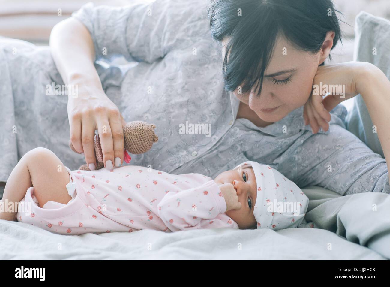 mother play with her newborn baby a teddy bear toy Stock Photo - Alamy