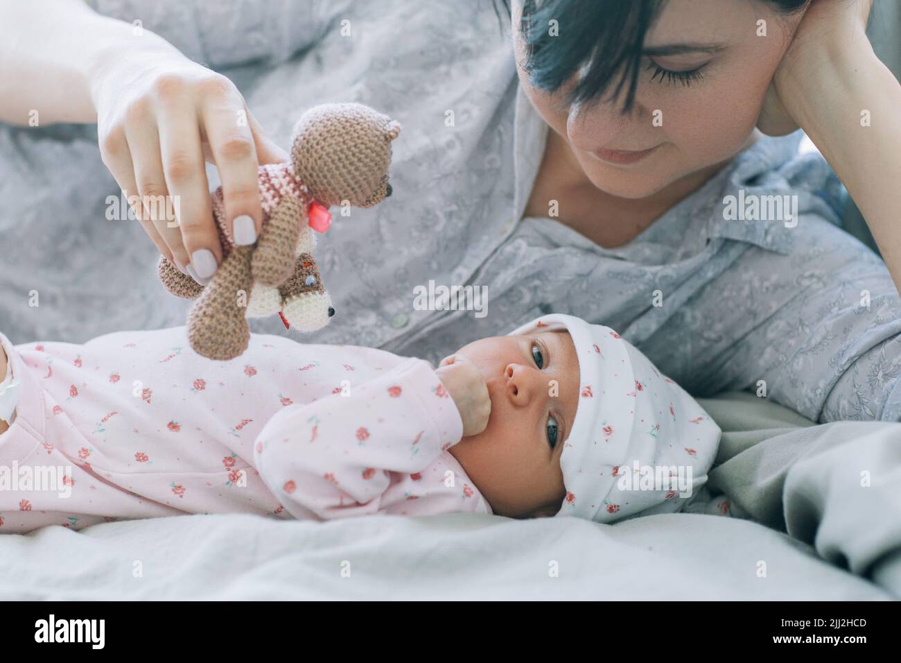 mother play with her newborn baby a teddy bear toy Stock Photo - Alamy