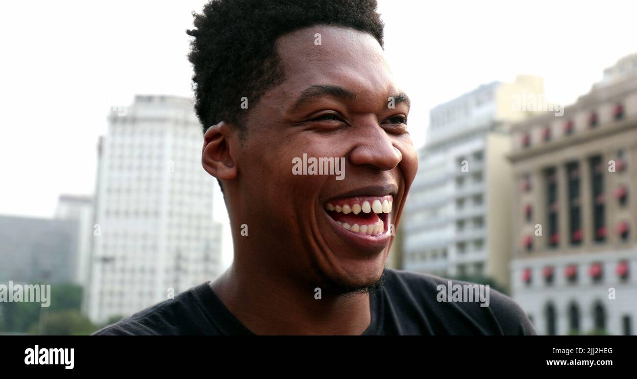 African black man smiling and laughing outside, real authentic people ...