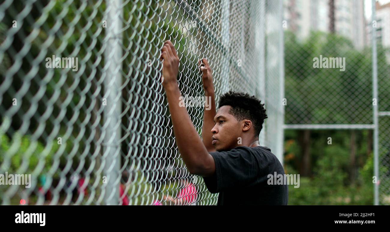 People leaning on metal fence hi-res stock photography and images - Alamy