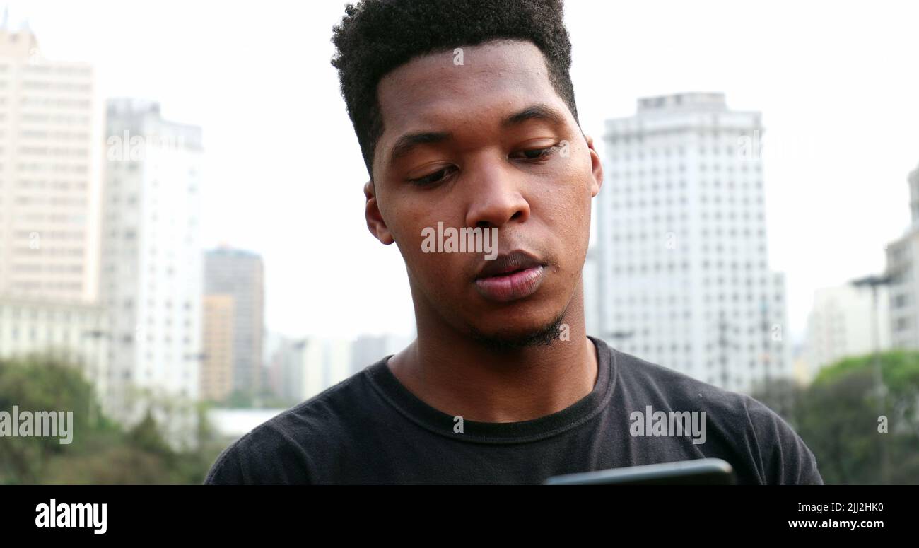 African black man using cellphone in street Stock Photo - Alamy