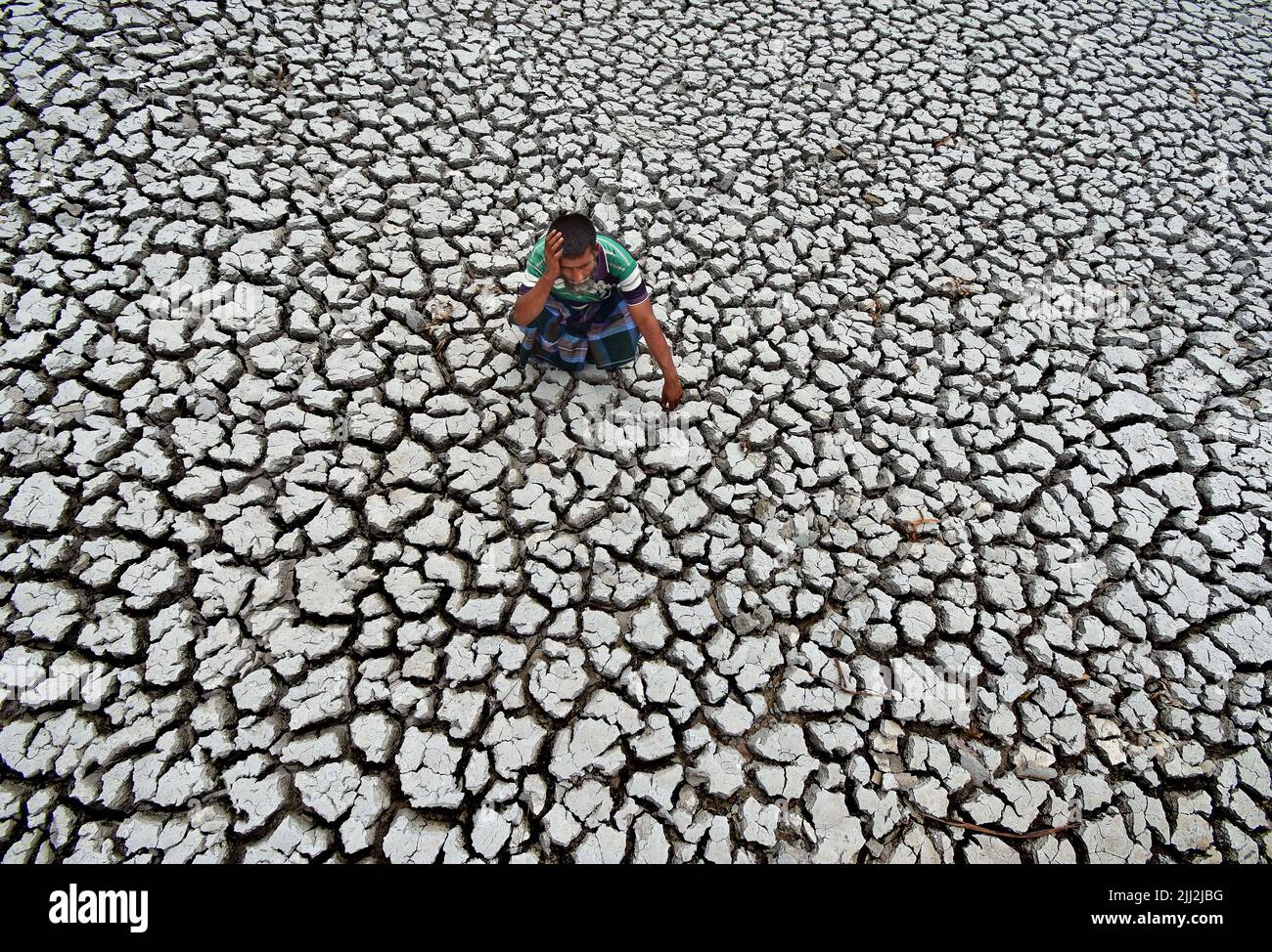 Cracked dry farmland under scorching sun, symbolizing drought, climate ...