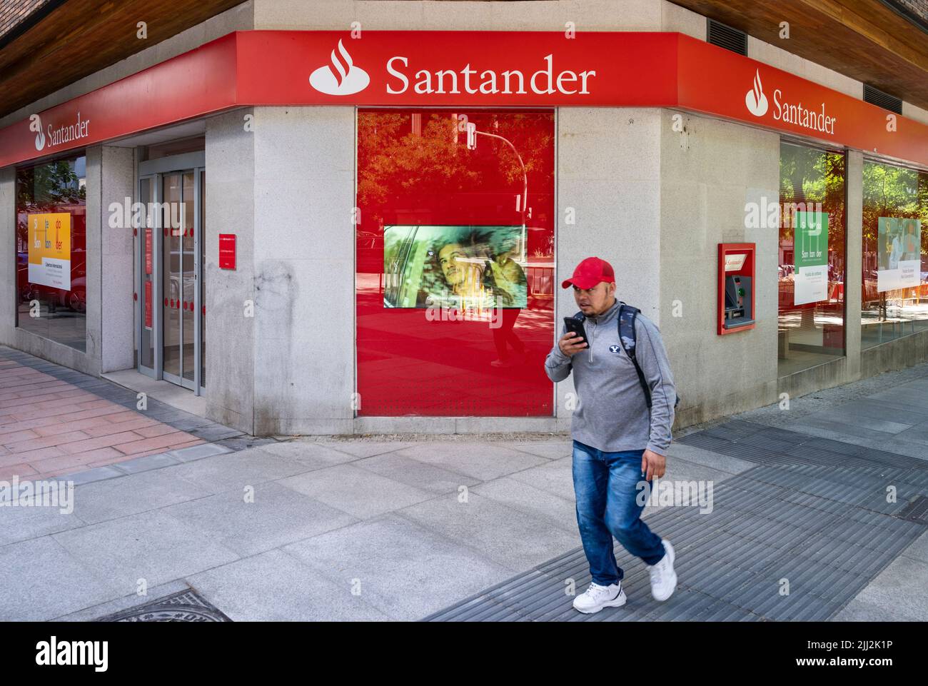 A pedestrian walks past the Spanish multinational commercial bank and ...