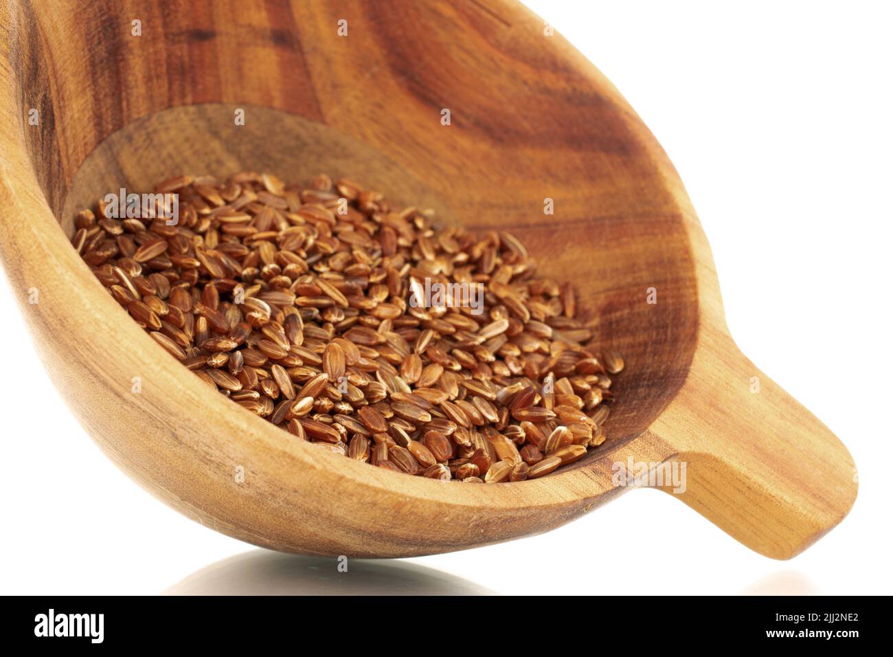 Organic uncooked brown rice in a wooden cup, close-up, isolated on ...