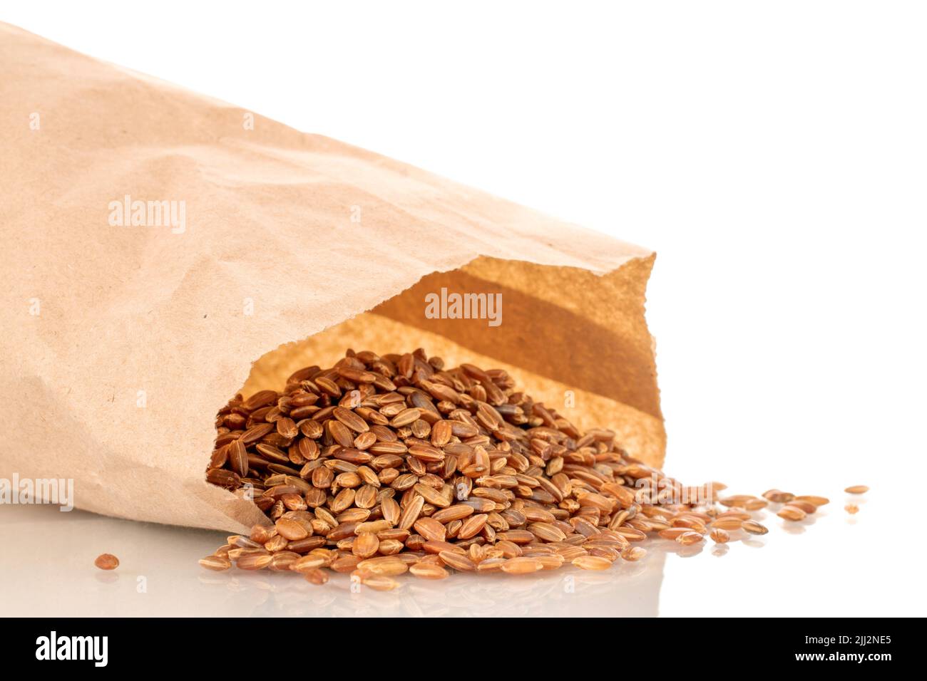 Organic uncooked brown rice in a paper bag, close-up, isolated on white ...