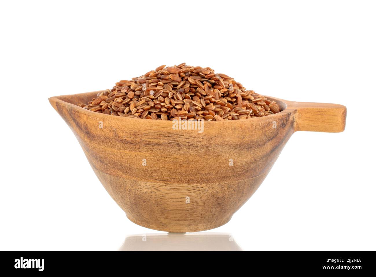 Organic uncooked brown rice in a wooden cup, close-up, isolated on ...