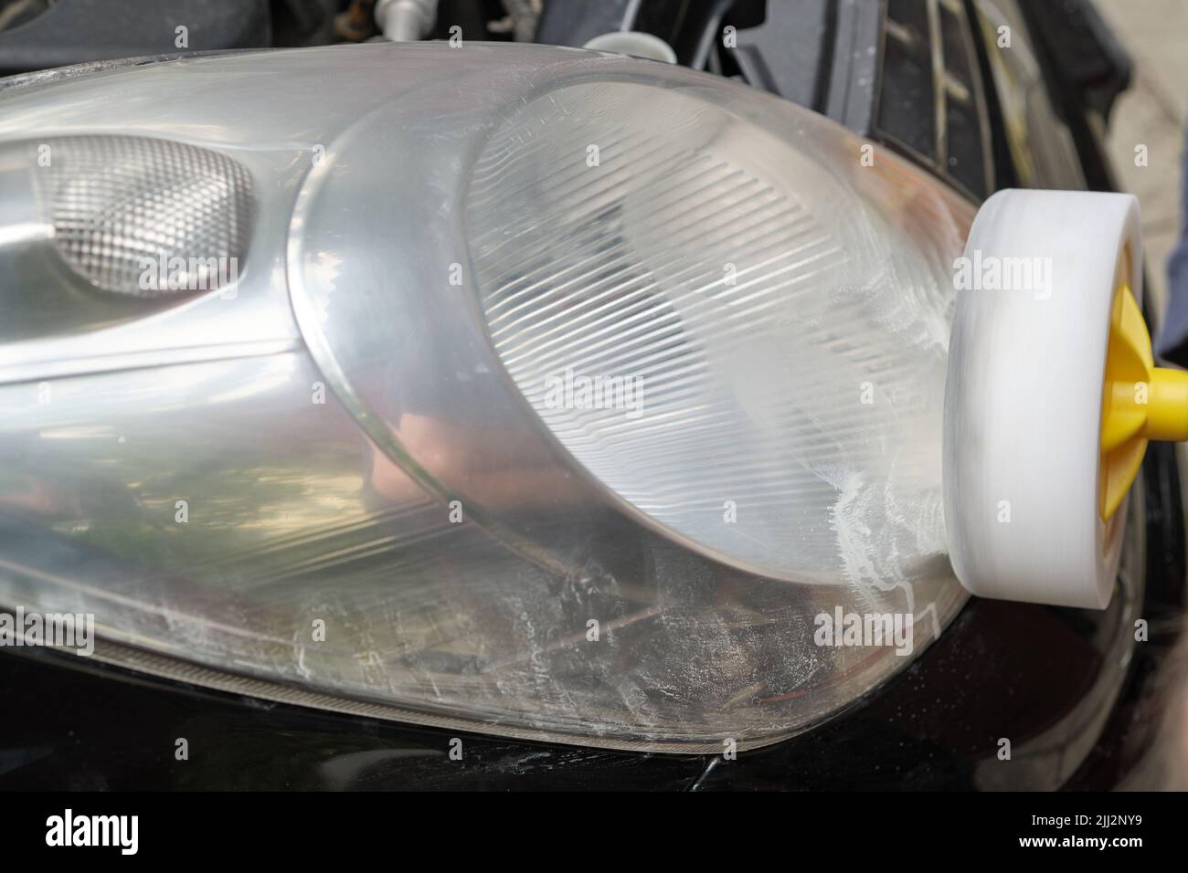 Big headlight cleaning with power buffer machine at service station ...