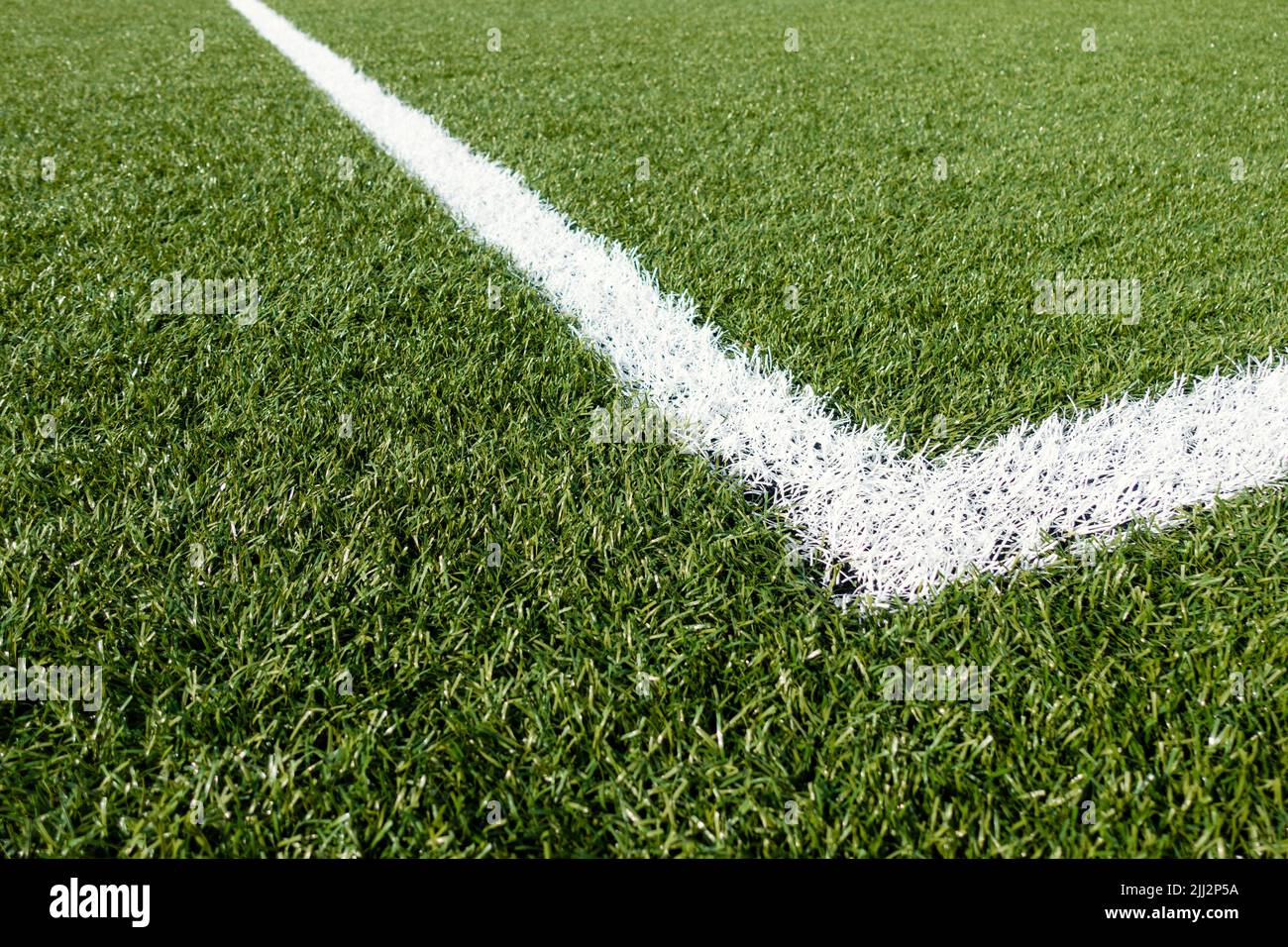 Green synthetic artificial grass soccer sports field with white corner ...
