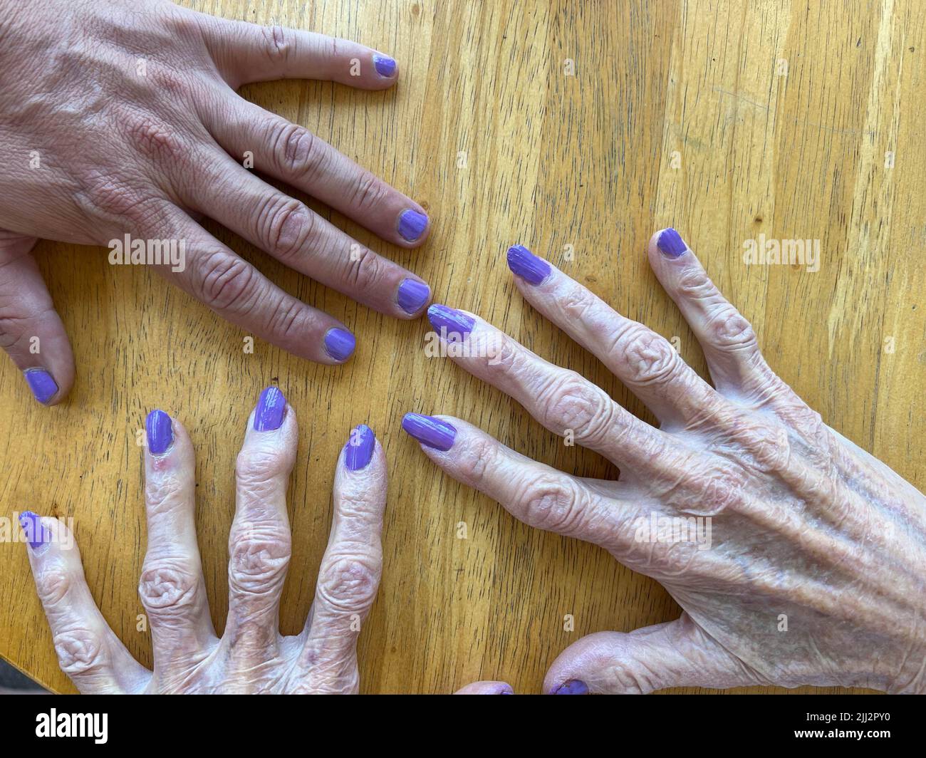 Senior grandmother and grandson manicure and polish their nails ...