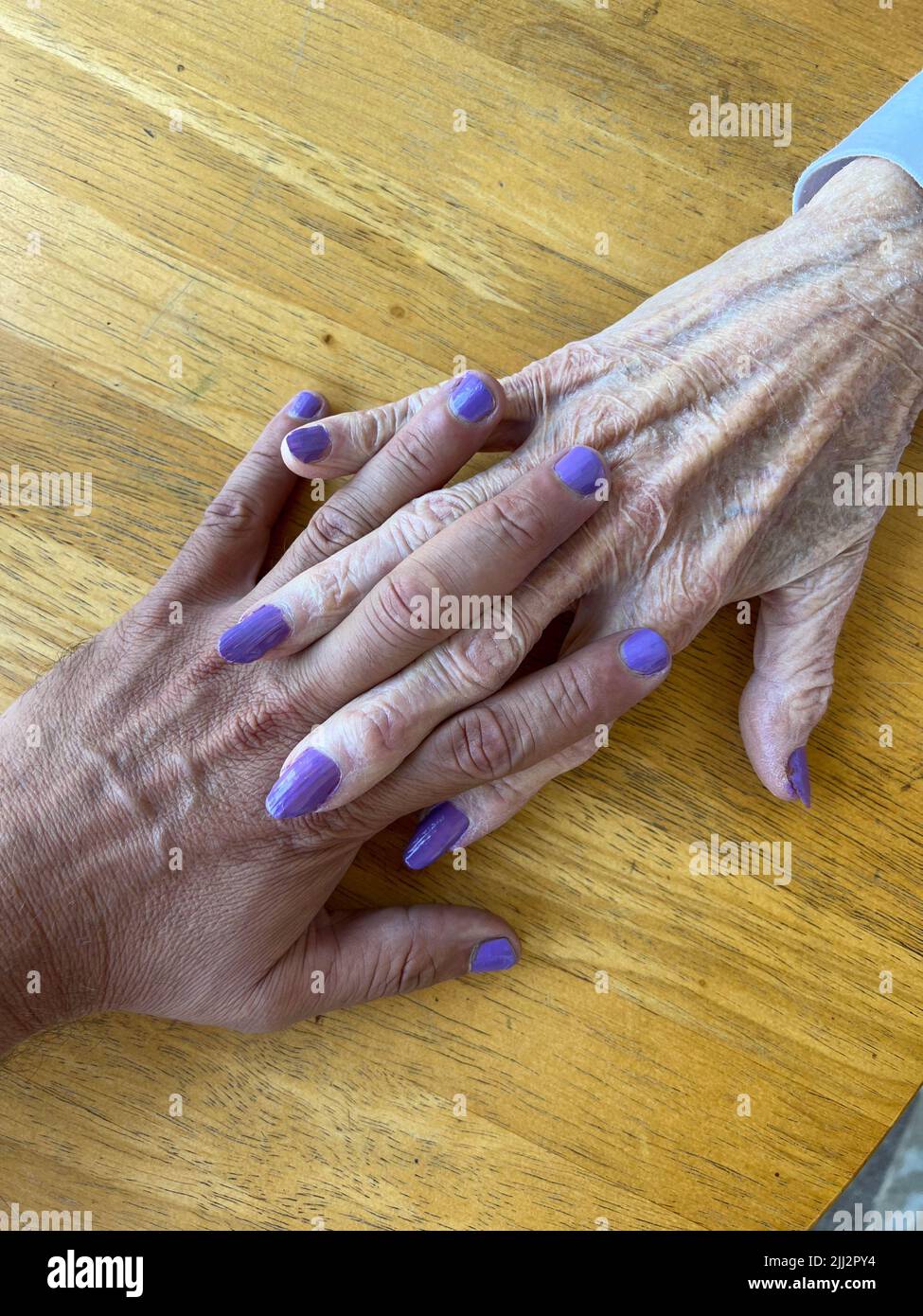 Senior grandmother and grandson manicure and polish their nails ...