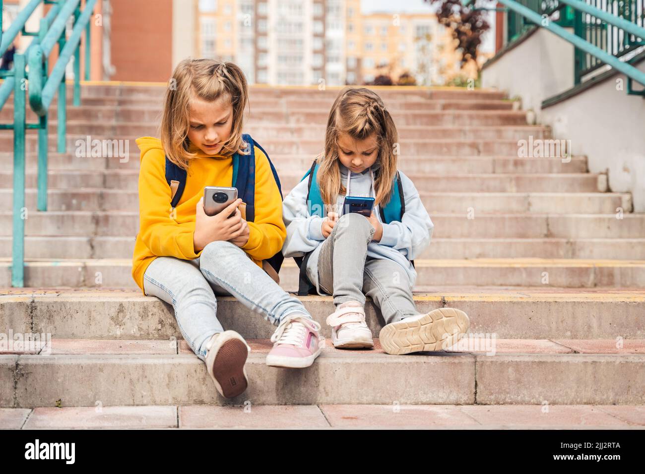 Back to elementary,primary school. Little girls with backpack,mobile ...