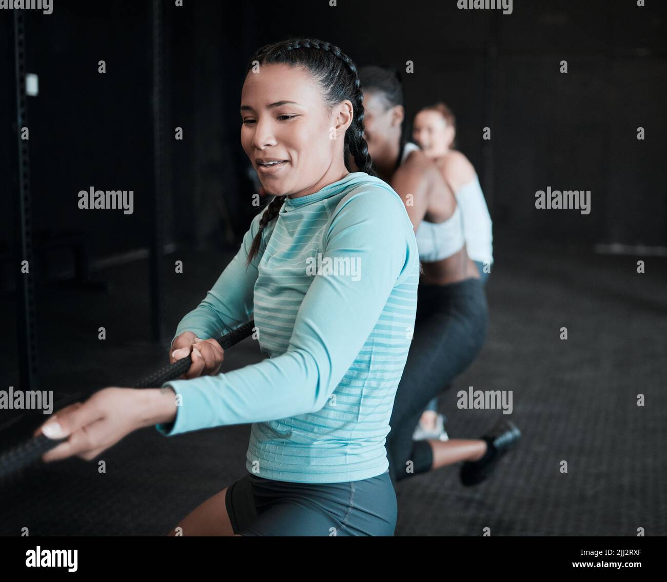 Women doing it for themselves. a group of young women pulling a rope in ...