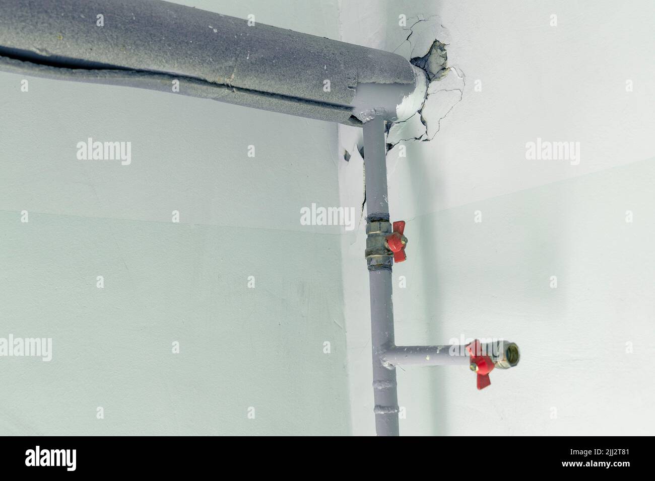 metal water pipes on the wall in a room with valves and fittings Stock ...