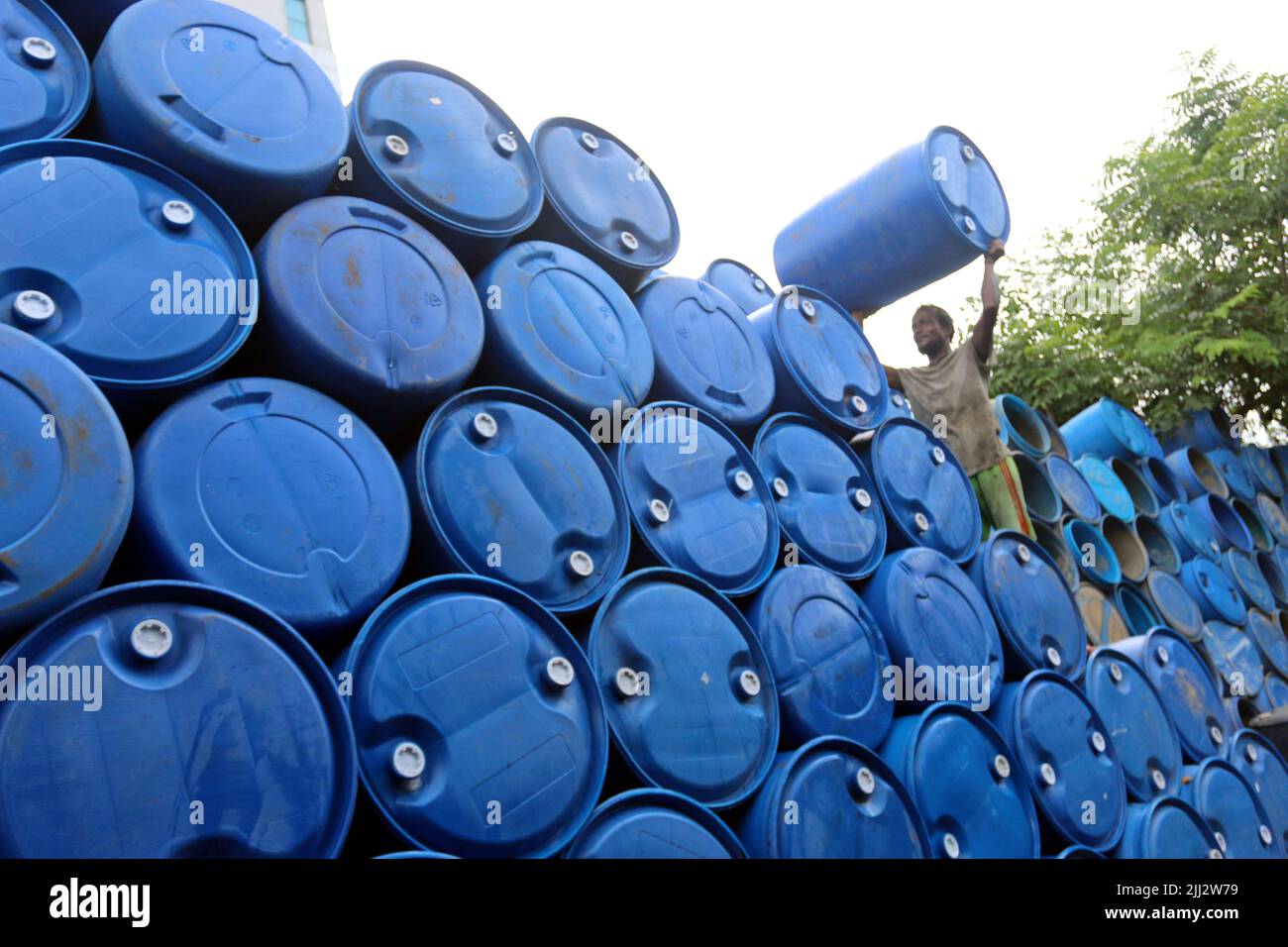 worker seen washing empty oil drums for recycling at a warehouse in ...