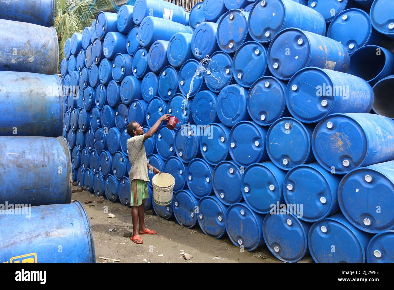worker seen washing empty oil drums for recycling at a warehouse in ...