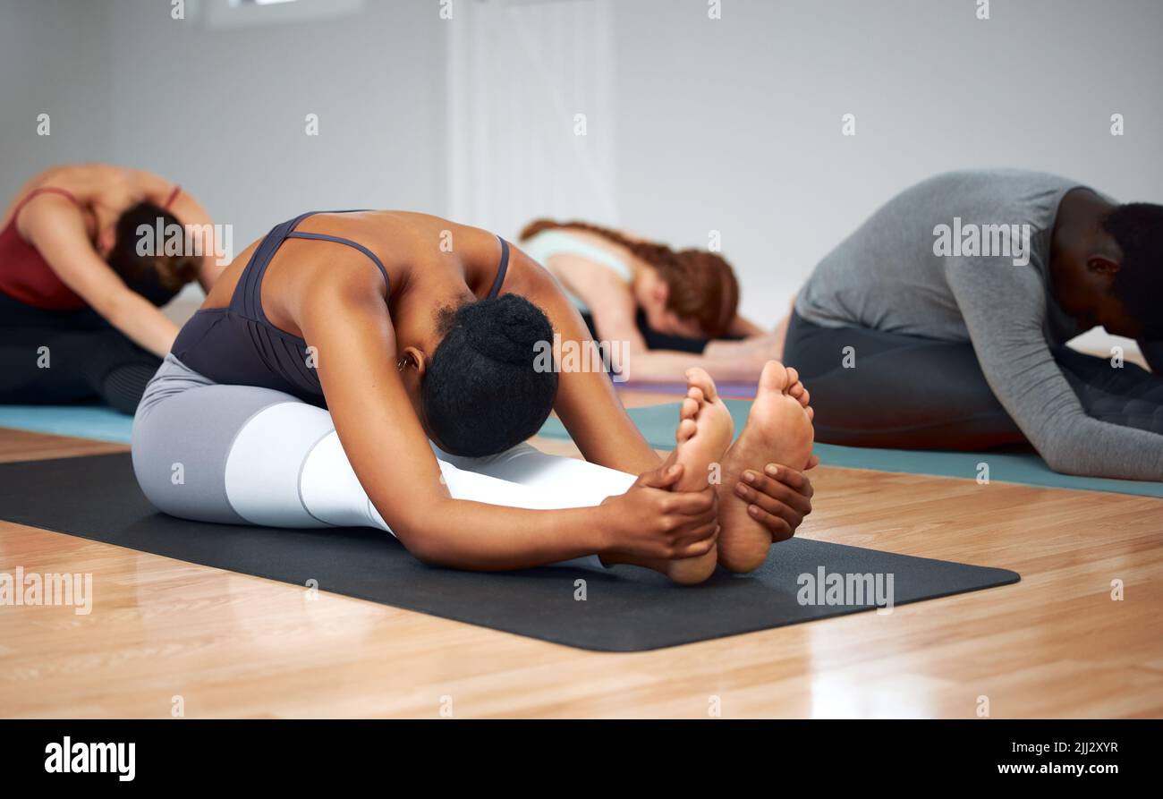 Take a moment to steady your breath. a group of people folding forward ...