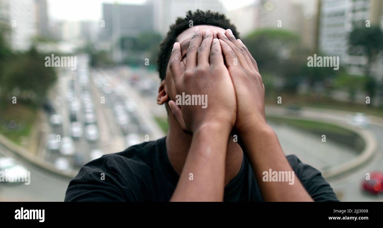 Anxious young black African man suffering in city Stock Photo - Alamy